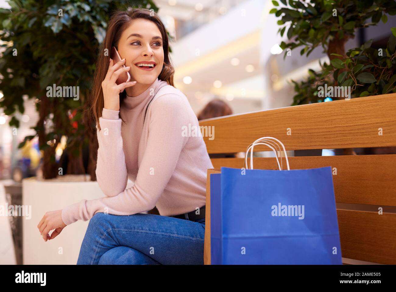 Young woman talking by mobile phone after big shopping Stock Photo - Alamy