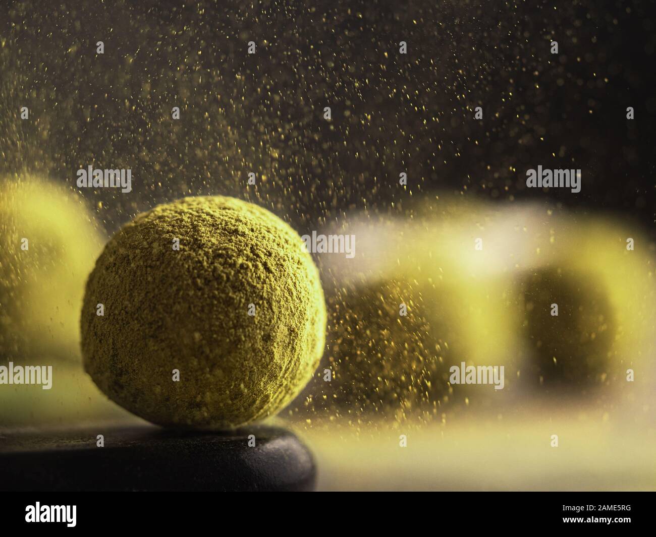 Homemade truffles candy with matcha tea powder in green tea dust cloud ...