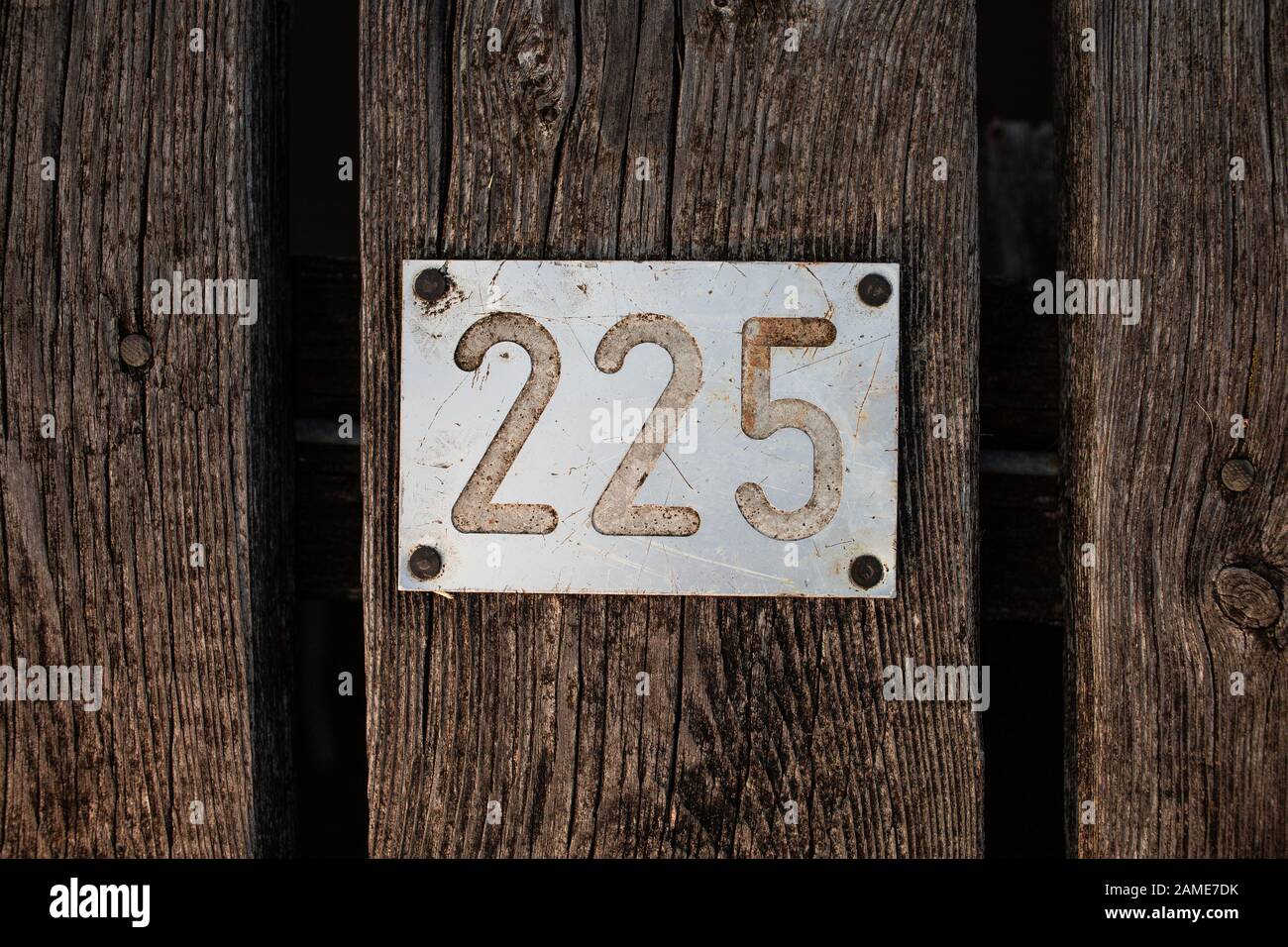 metal signboard with number on old wooden boards Stock Photo - Alamy