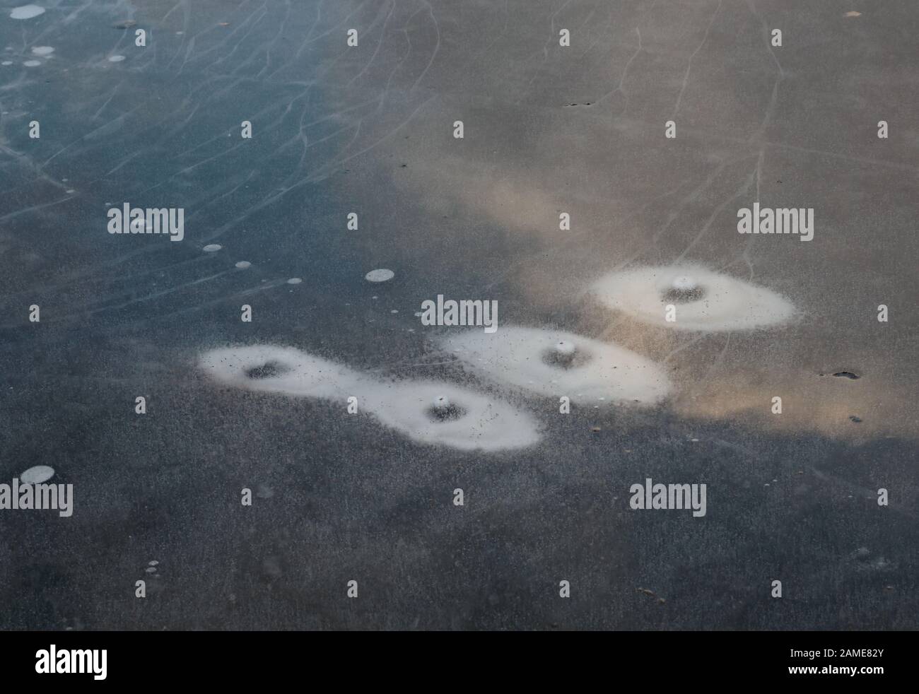 Water on ice melts it and forms various patterns on the ice surface ...