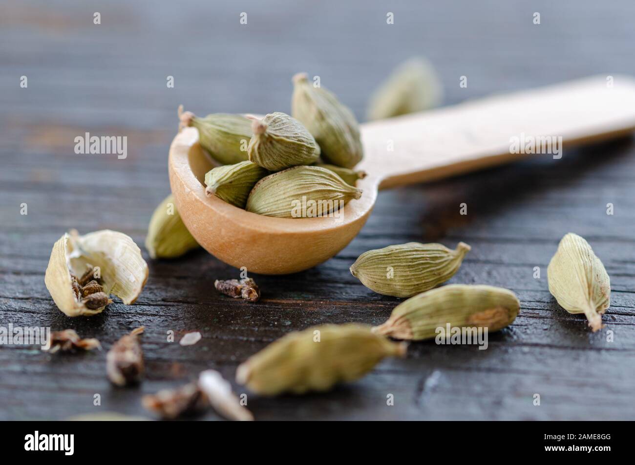 Dried green organic cardamom pods on wooden table, closeup and top view ...