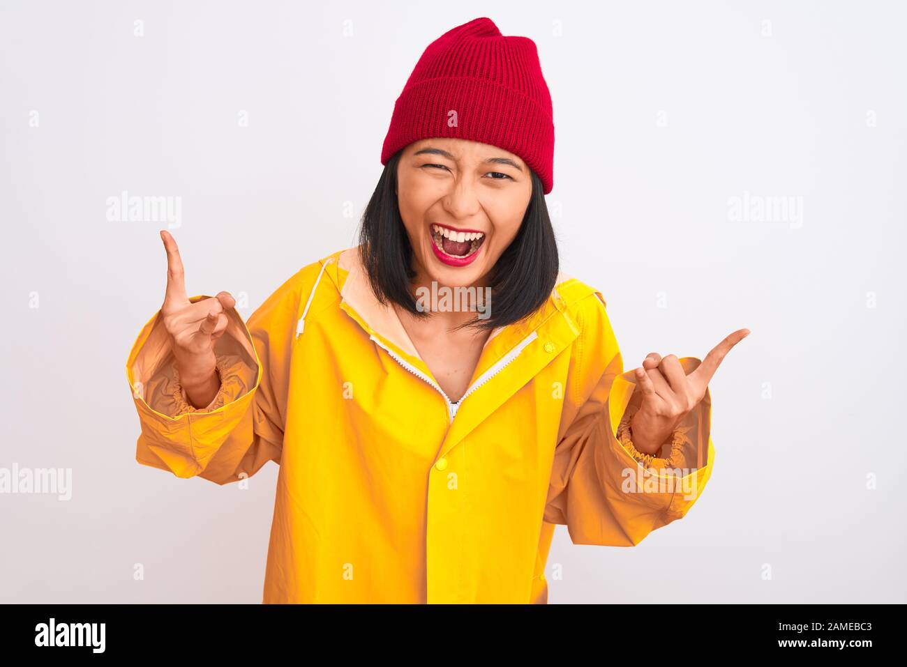Young beautiful chinese woman wearing raincoat and wool cap over ...