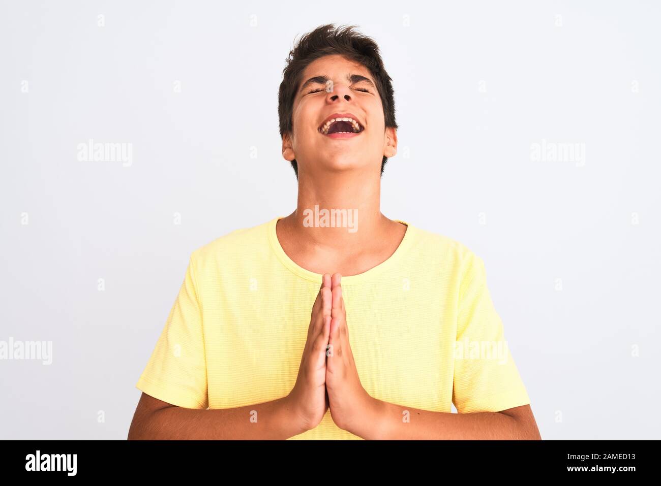 Handsome teenager boy standing over white isolated background begging ...