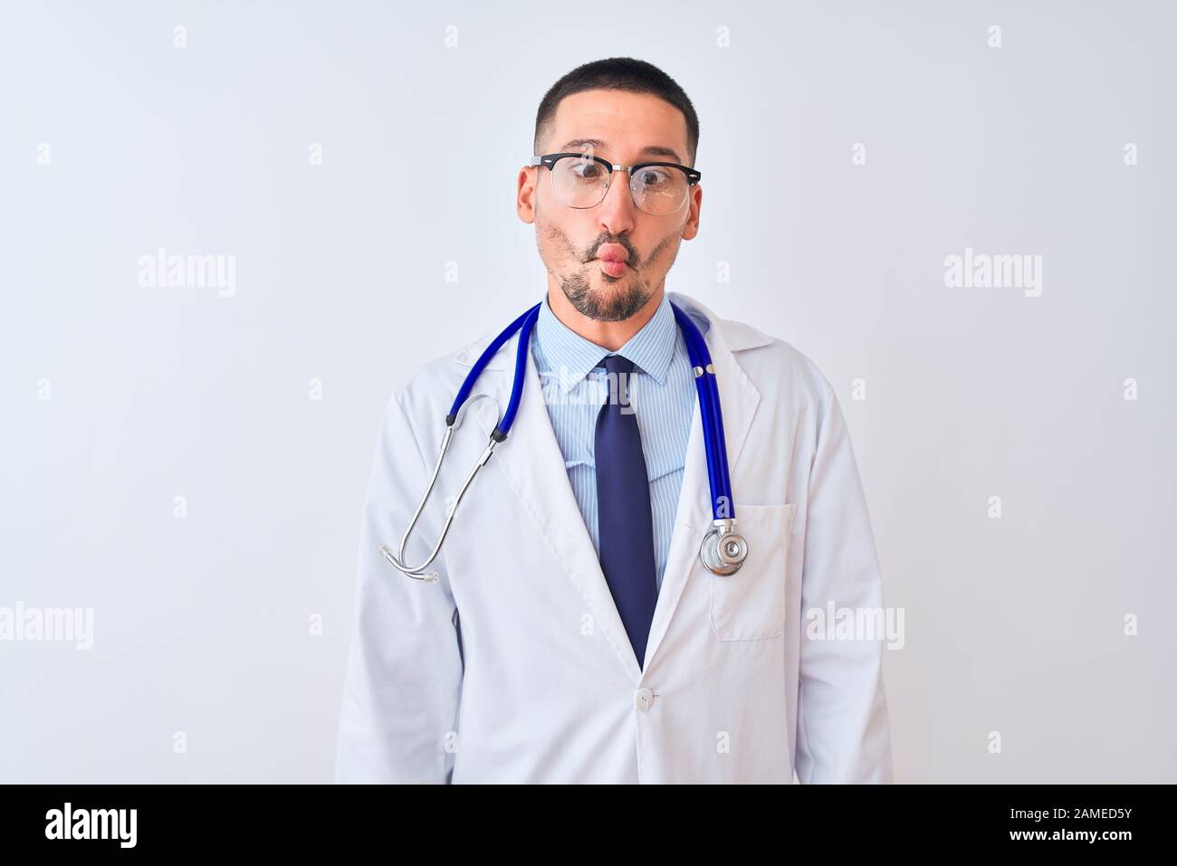 Young doctor man wearing stethoscope over isolated background making ...