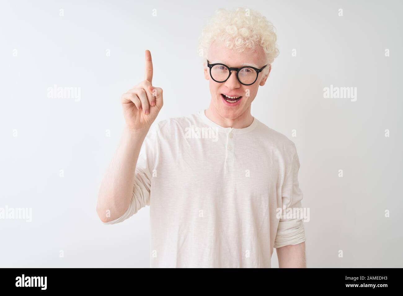 Young albino blond man wearing t-shirt and glasses standing over ...