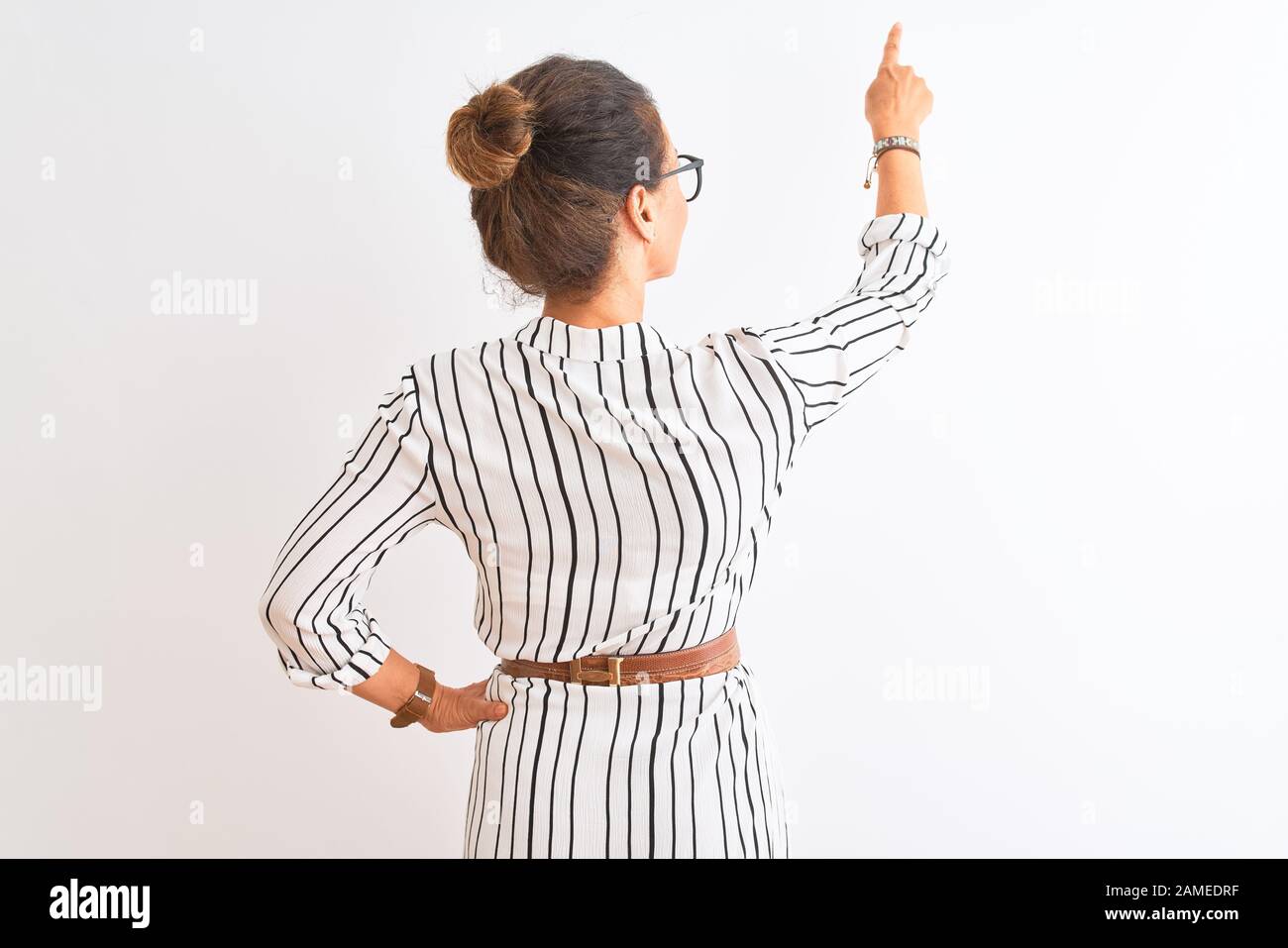 Middle age businesswoman wearing striped dress and glasses over ...
