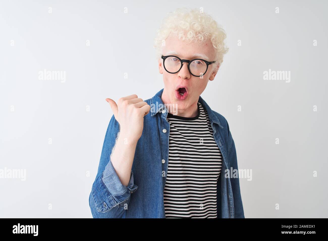 Young albino blond man wearing denim shirt and glasses over isolated ...