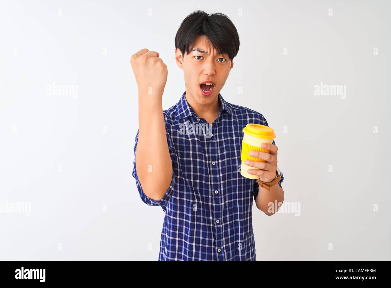 Young chinese man drinking take away coffee standing over isolated ...