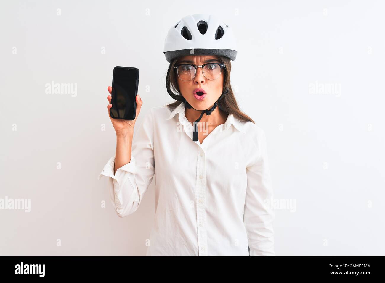 Young businesswoman wearing bike helmet holding smartphone over ...