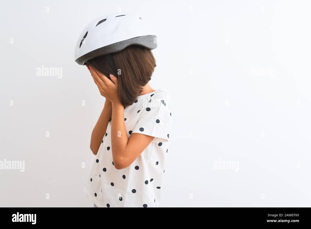 Beautiful child girl wearing security bike helmet standing over ...