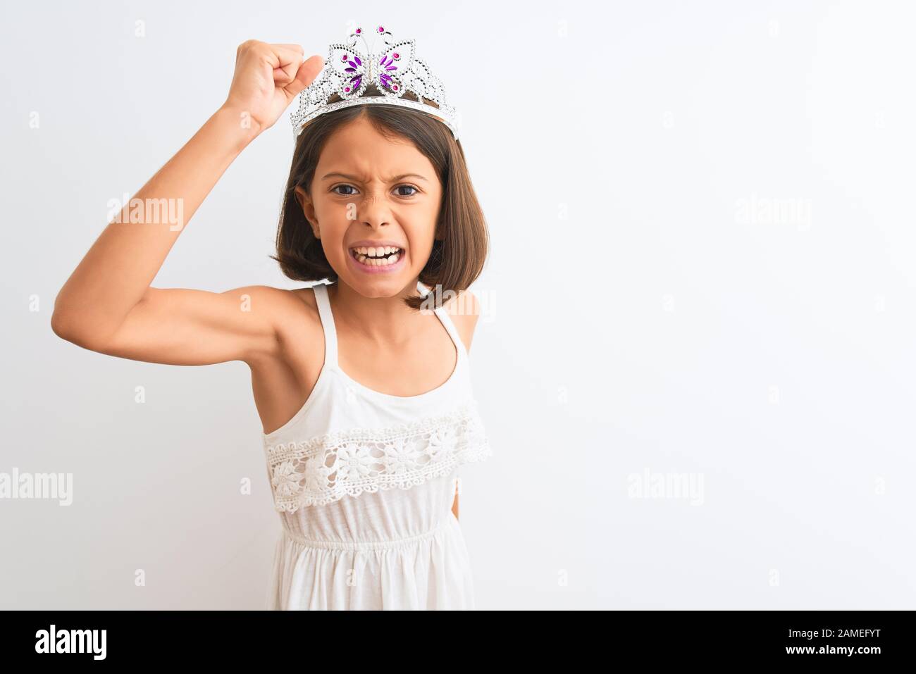 Beautiful child girl wearing princess crown standing over isolated ...
