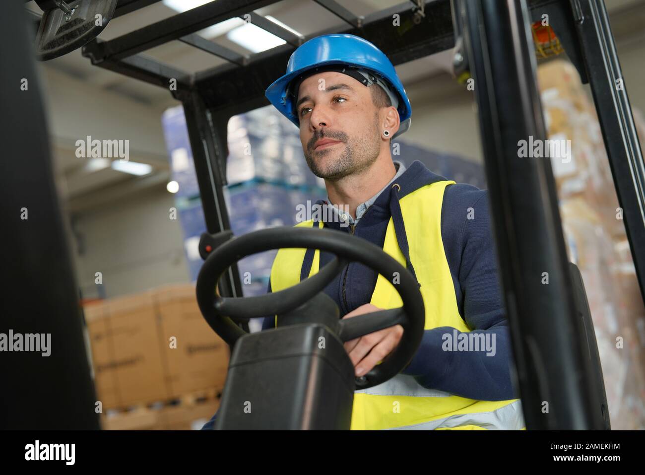 Warehouse operator driving cart Stock Photo - Alamy