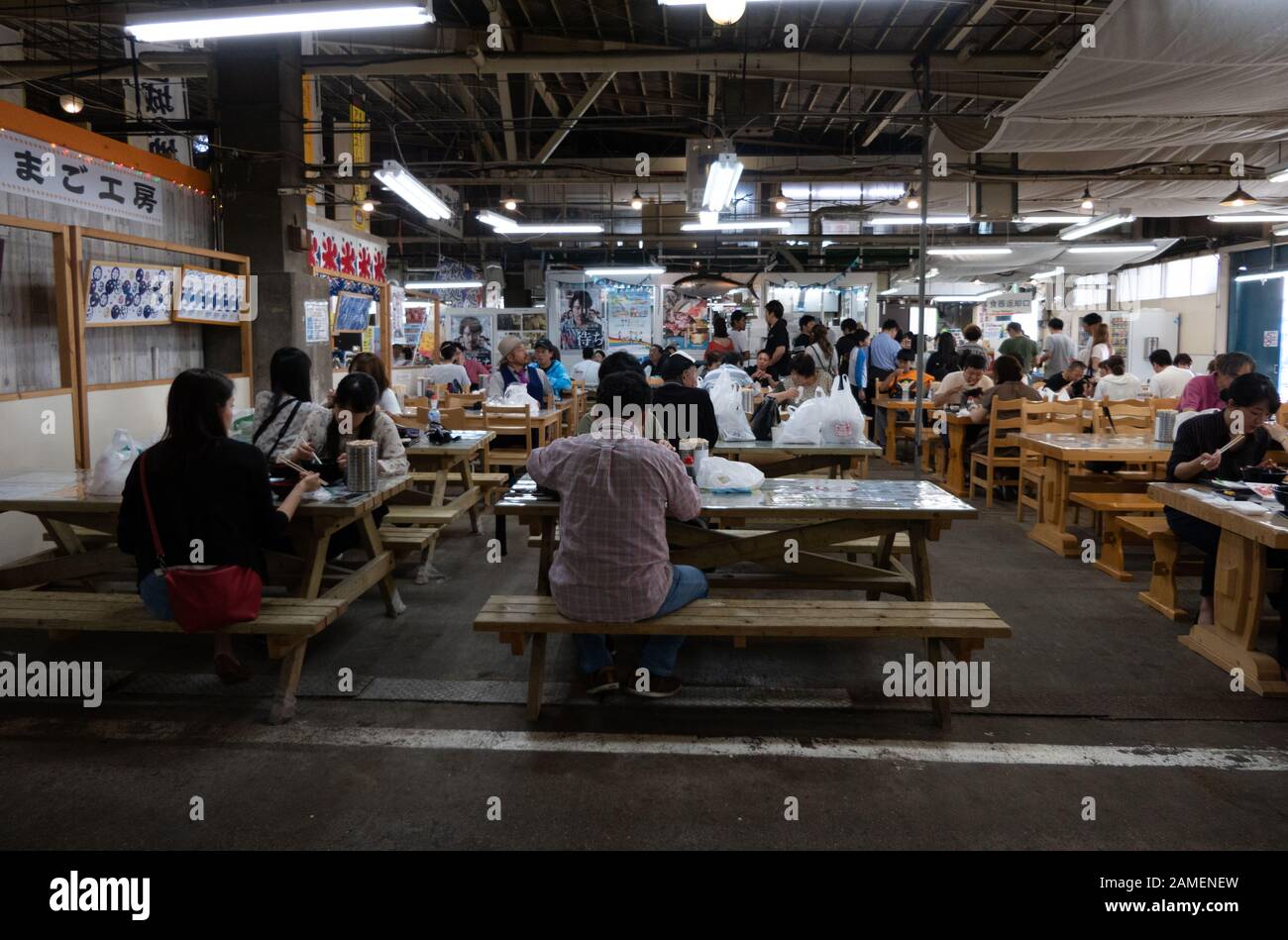 Families and people eating tuna, sushi and fresh seafood at fish market ...