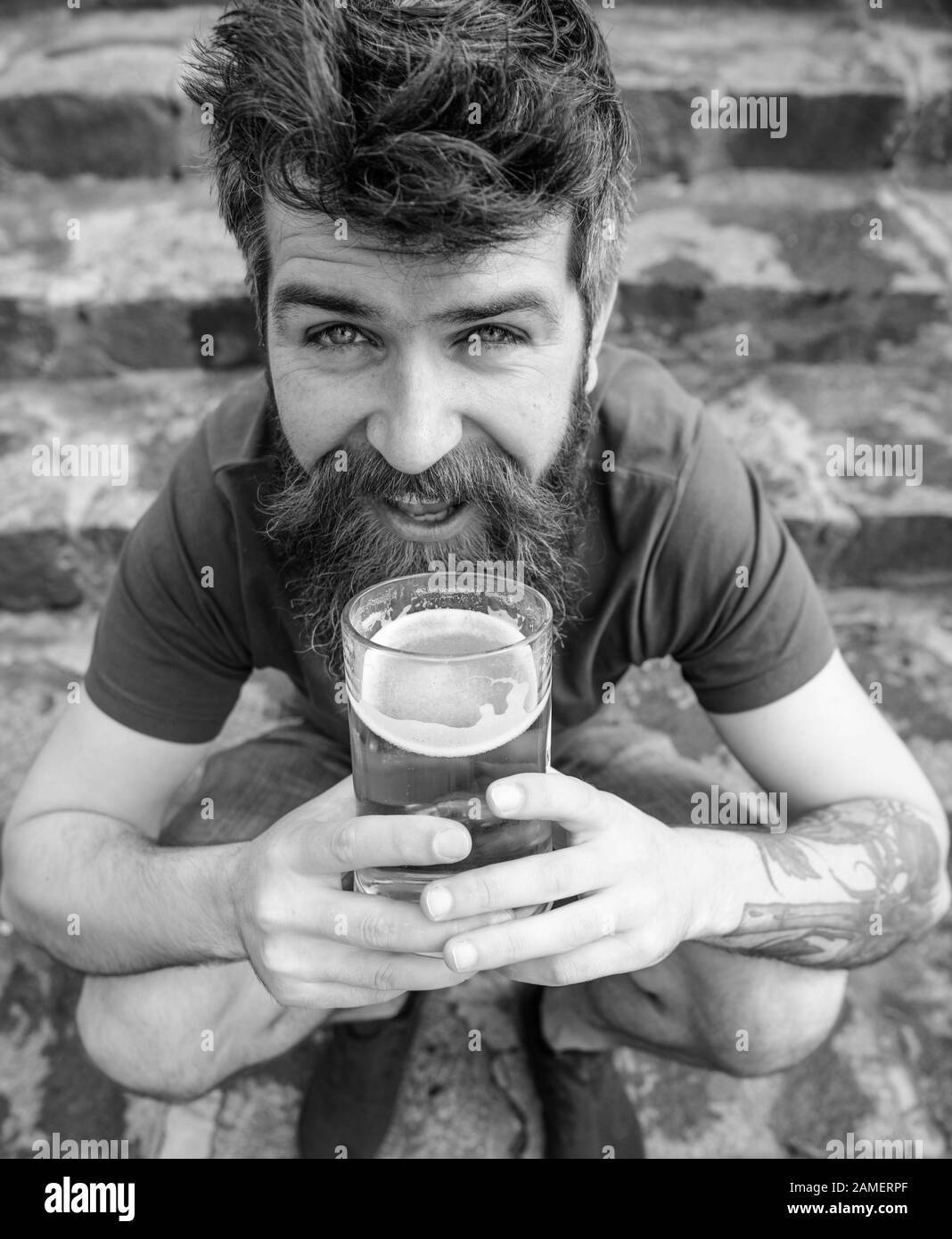 Hipster on cheerful face drinking beer outdoor. Guy having rest with ...
