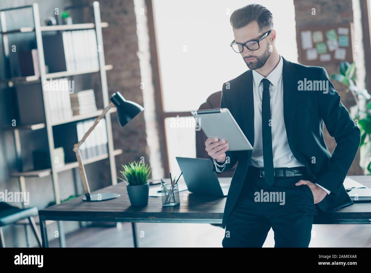 Photo of successful handsome business guy hold tablet look screen check ...