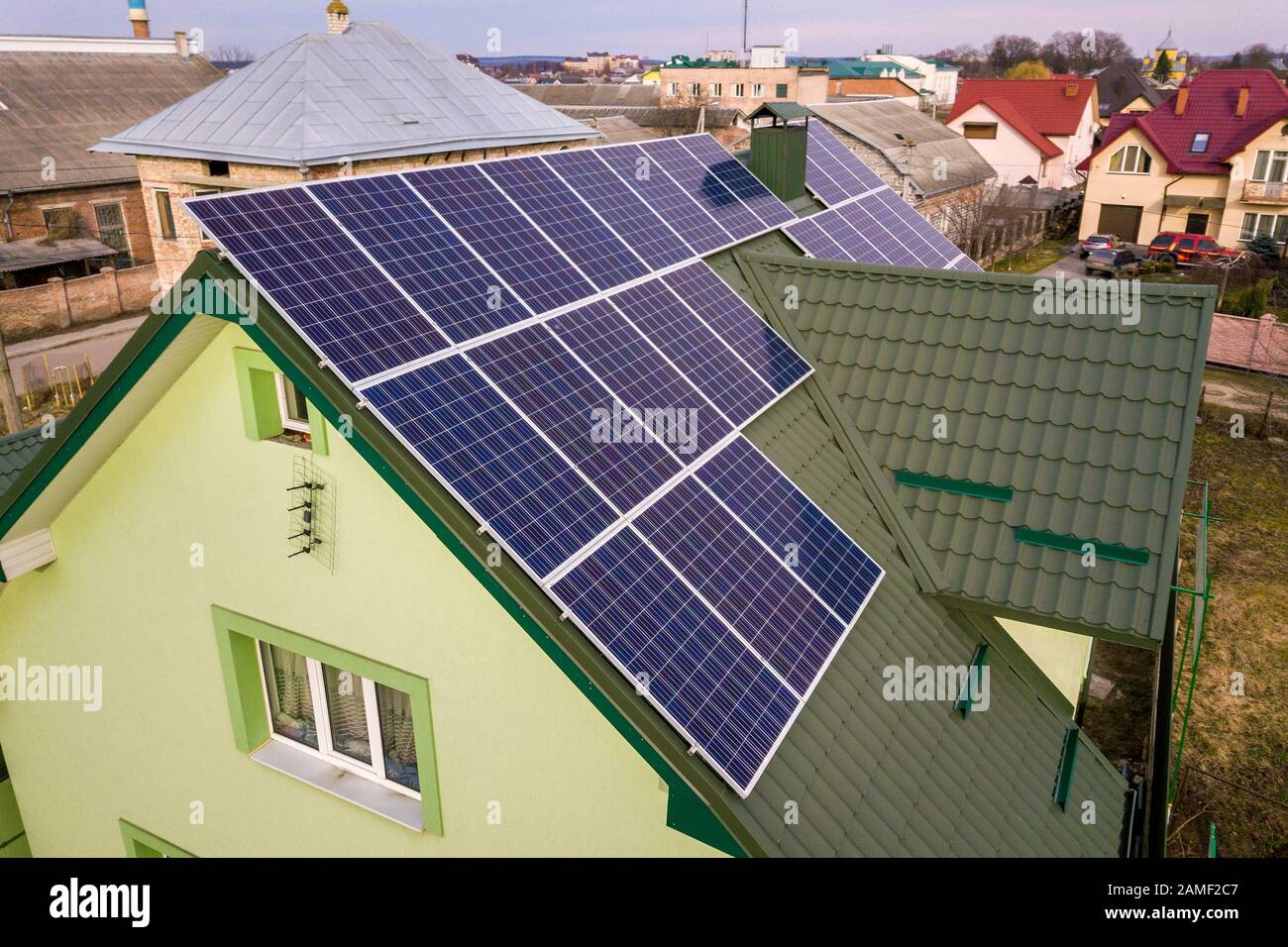 Aerial view of house cottage with blue shiny solar photo voltaic panels ...
