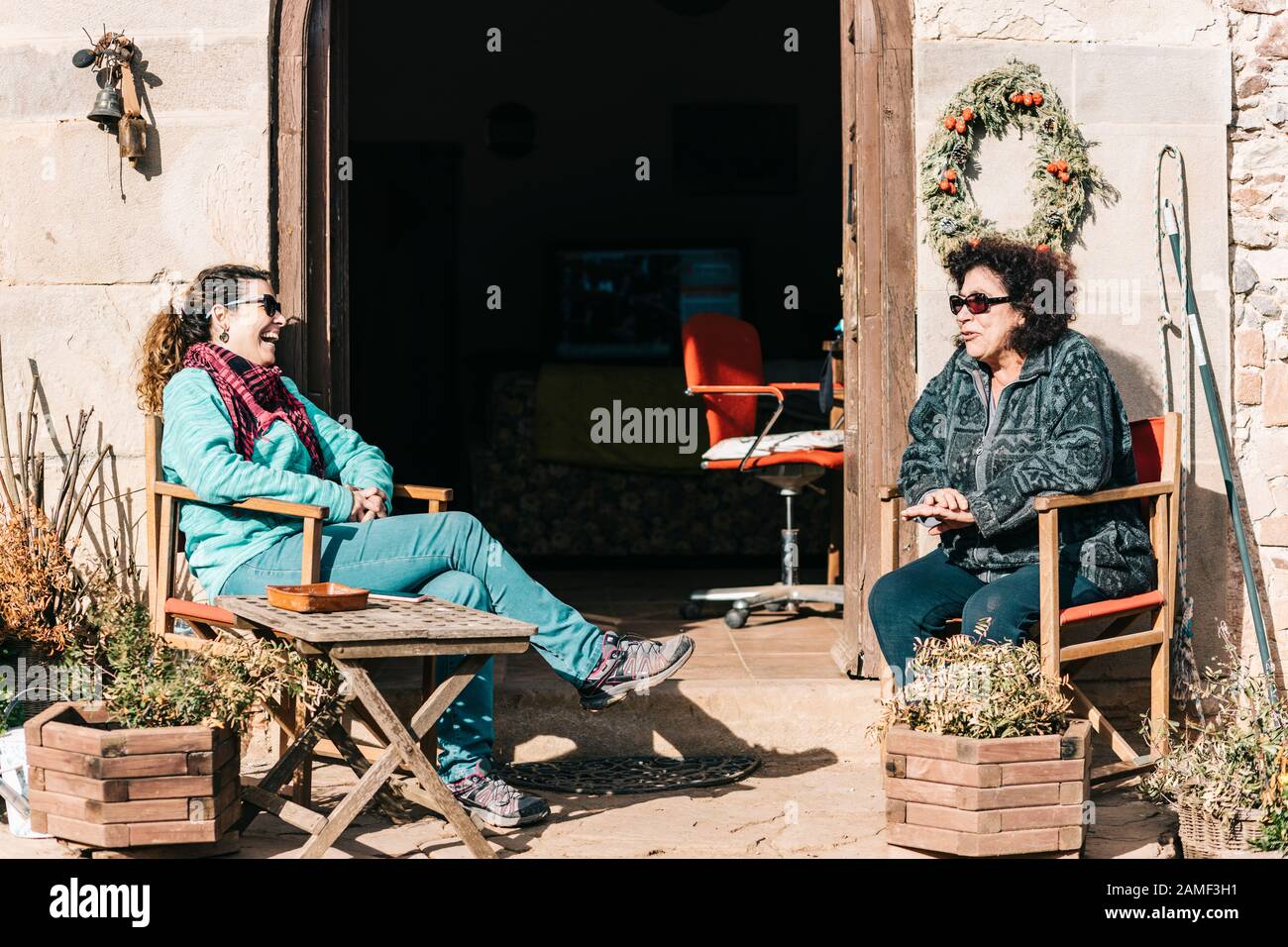 Two neighbors sitting outdoors of their house Stock Photo - Alamy