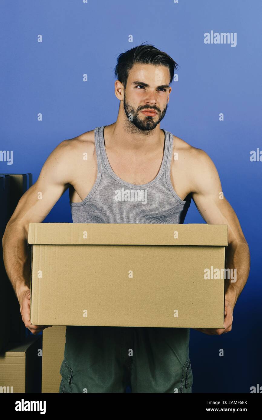 Delivery and moving in concept. Man standing among cardboard boxes and ...