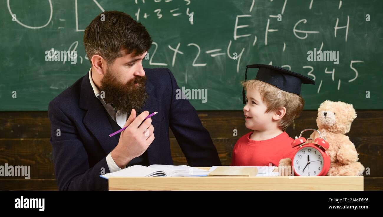 Kid studying with teacher. Father teaches son, discuss, explain ...