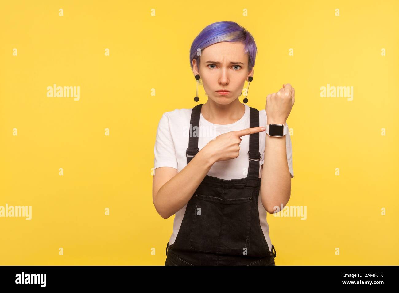Portrait of dissatisfied angry hipster girl with violet hair in denim ...