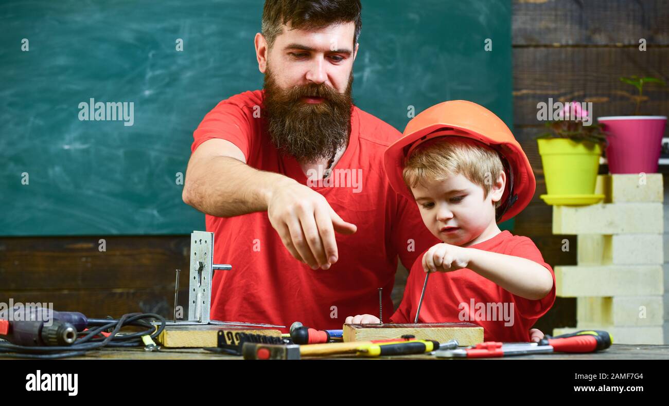 Team work concept. Boy, child busy in protective helmet makes by hand ...