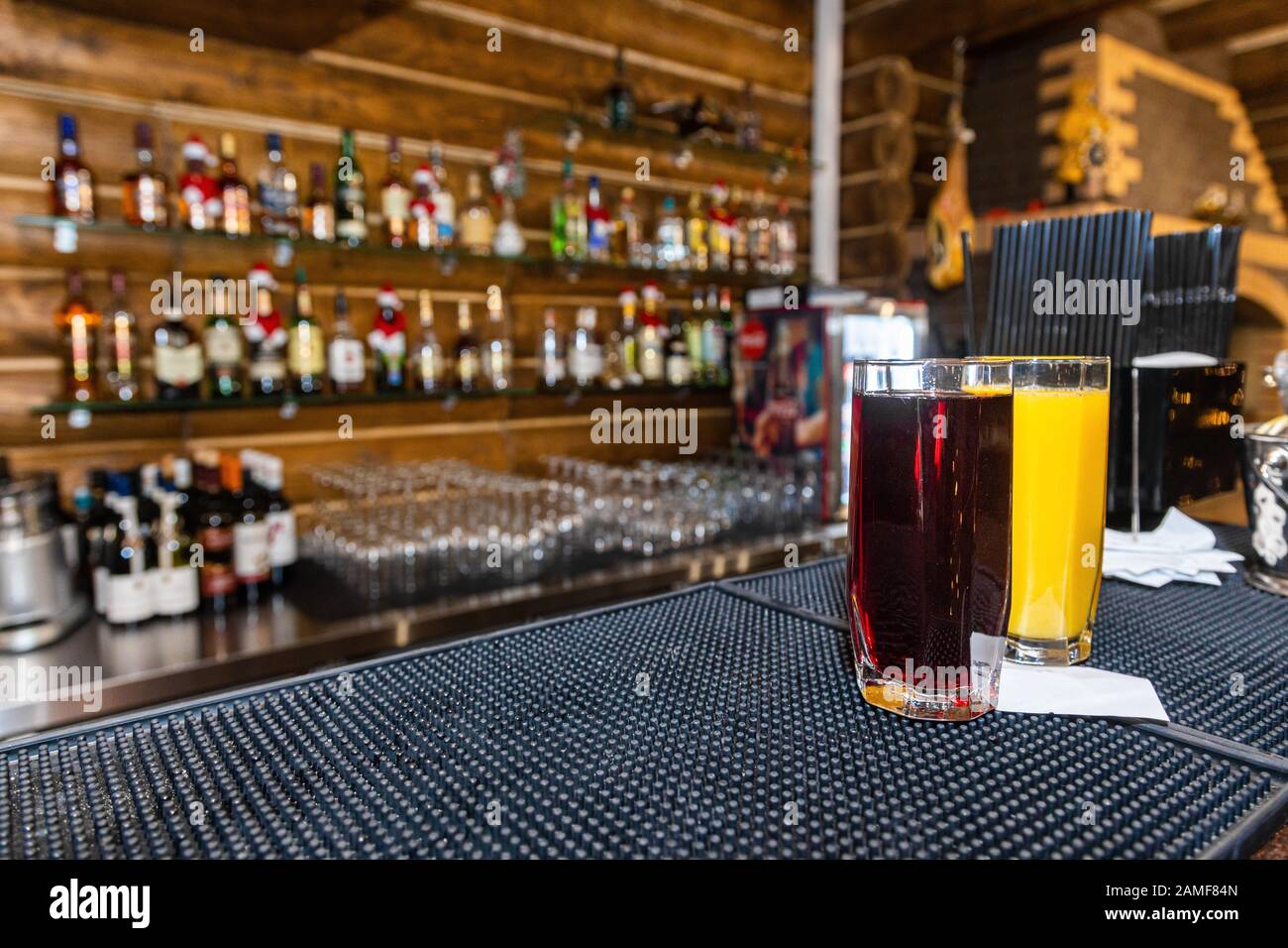 Multi-colored cocktails and soft drinks on a bar counter in glass ...