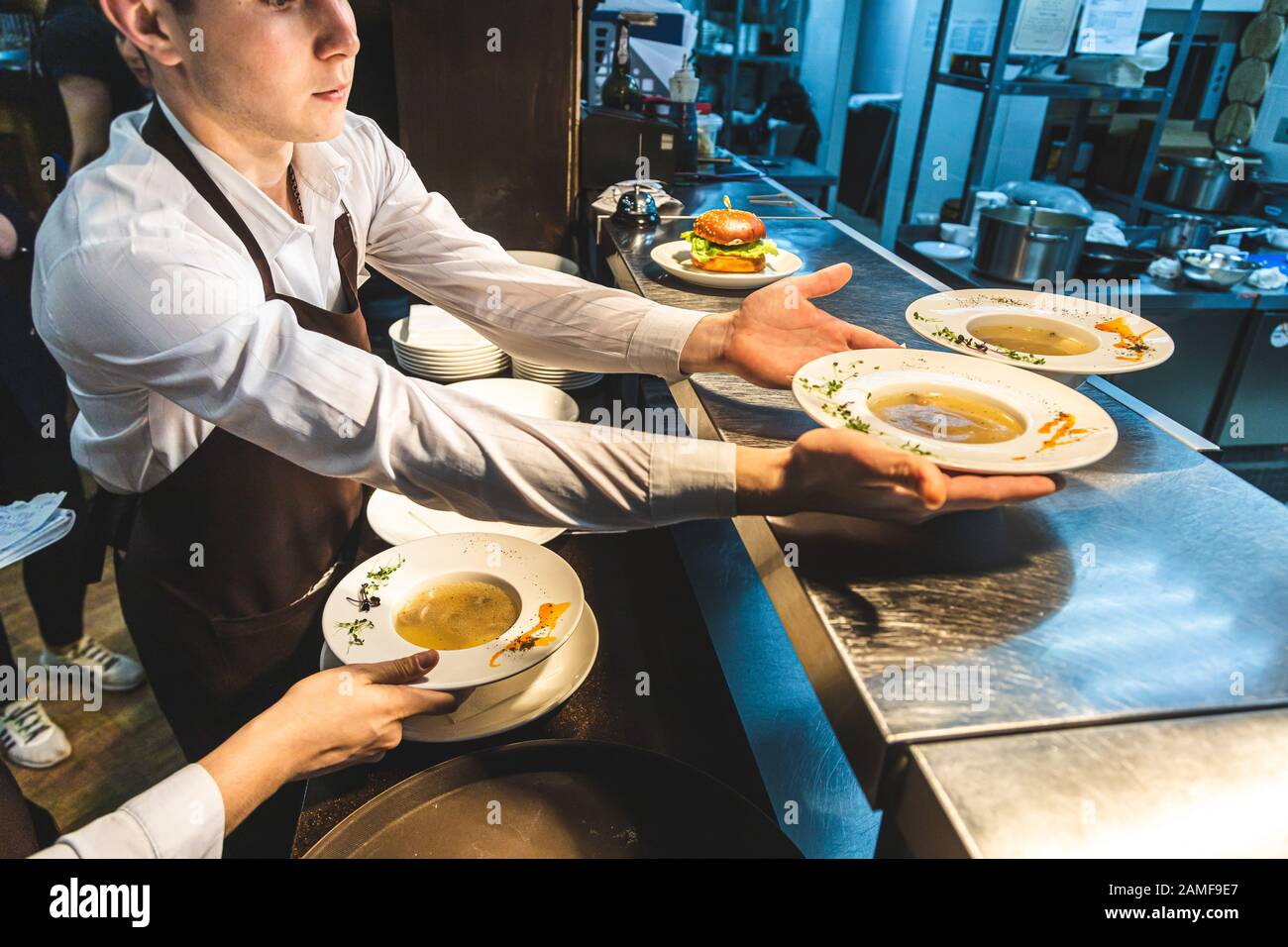 Waiters pick up ready meals in a restaurant at the counter for ...