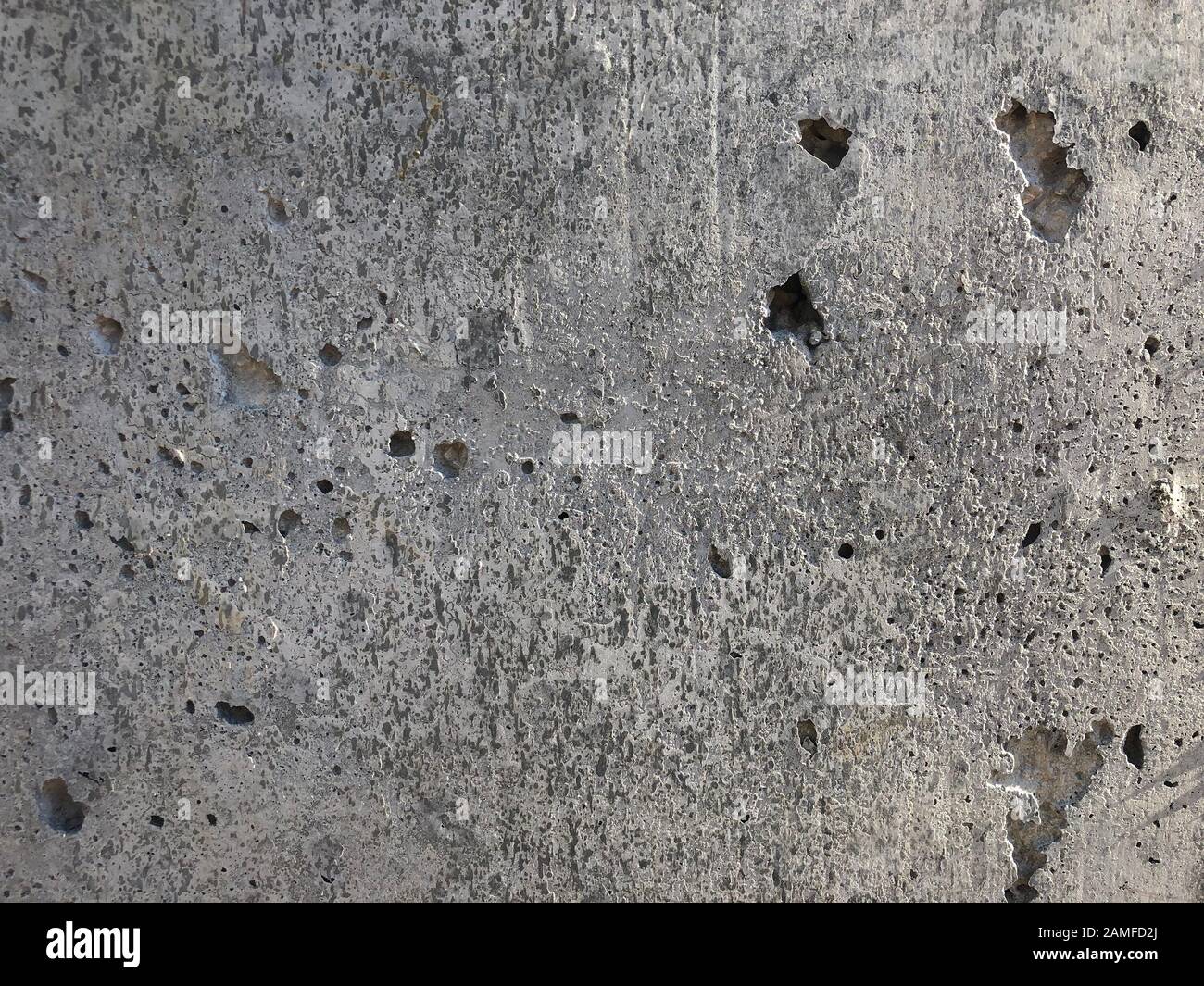 Concrete surface with caverns and exposed gravel stones Stock Photo - Alamy