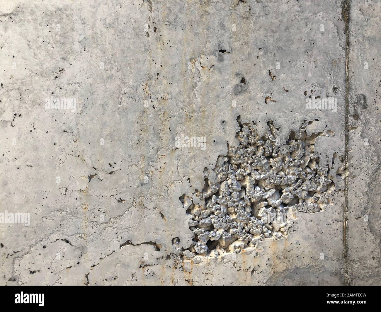 Concrete surface with caverns and exposed gravel stones Stock Photo - Alamy