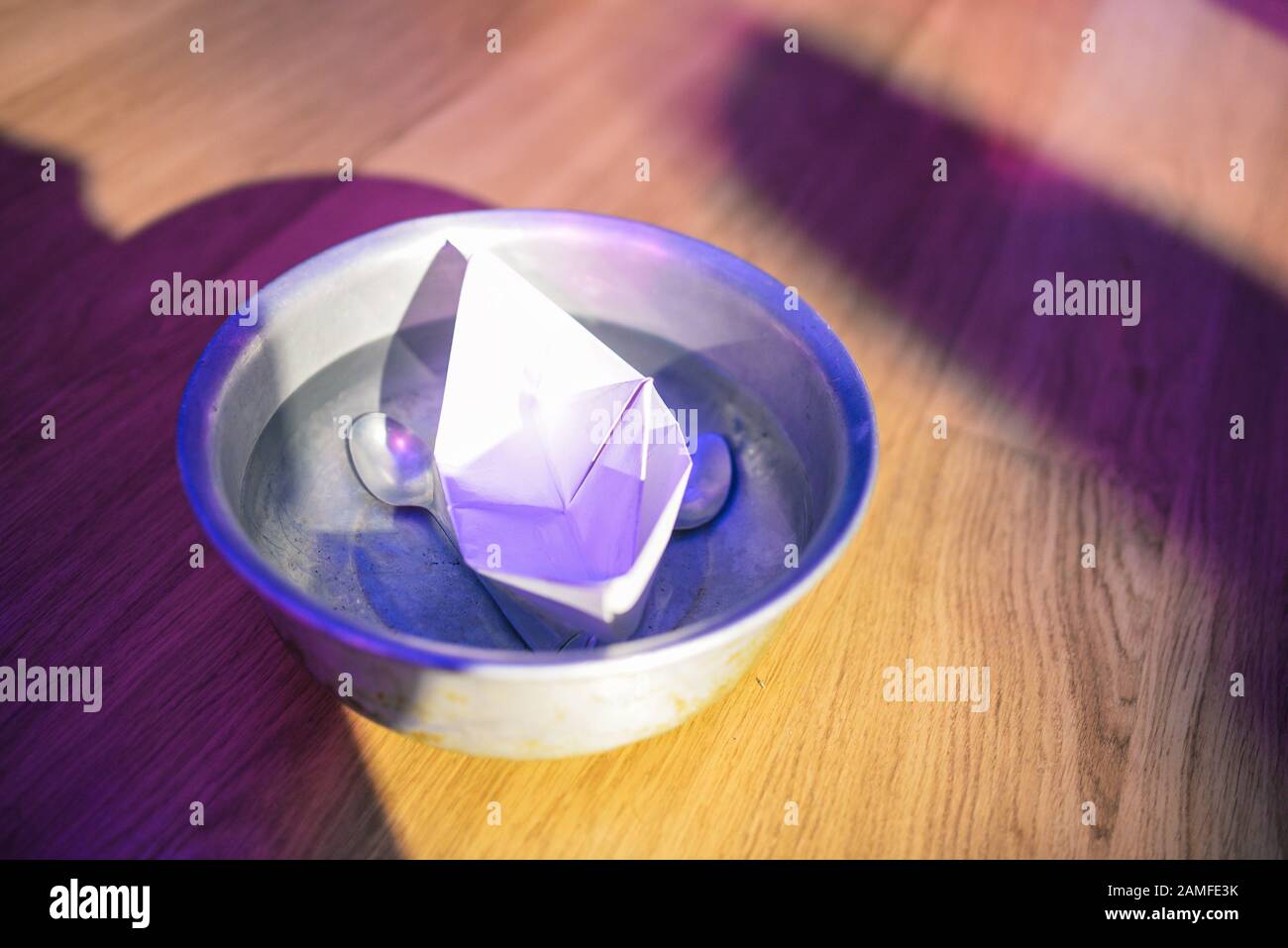 A paper boat floats in a basin. Origami paper craft Stock Photo - Alamy