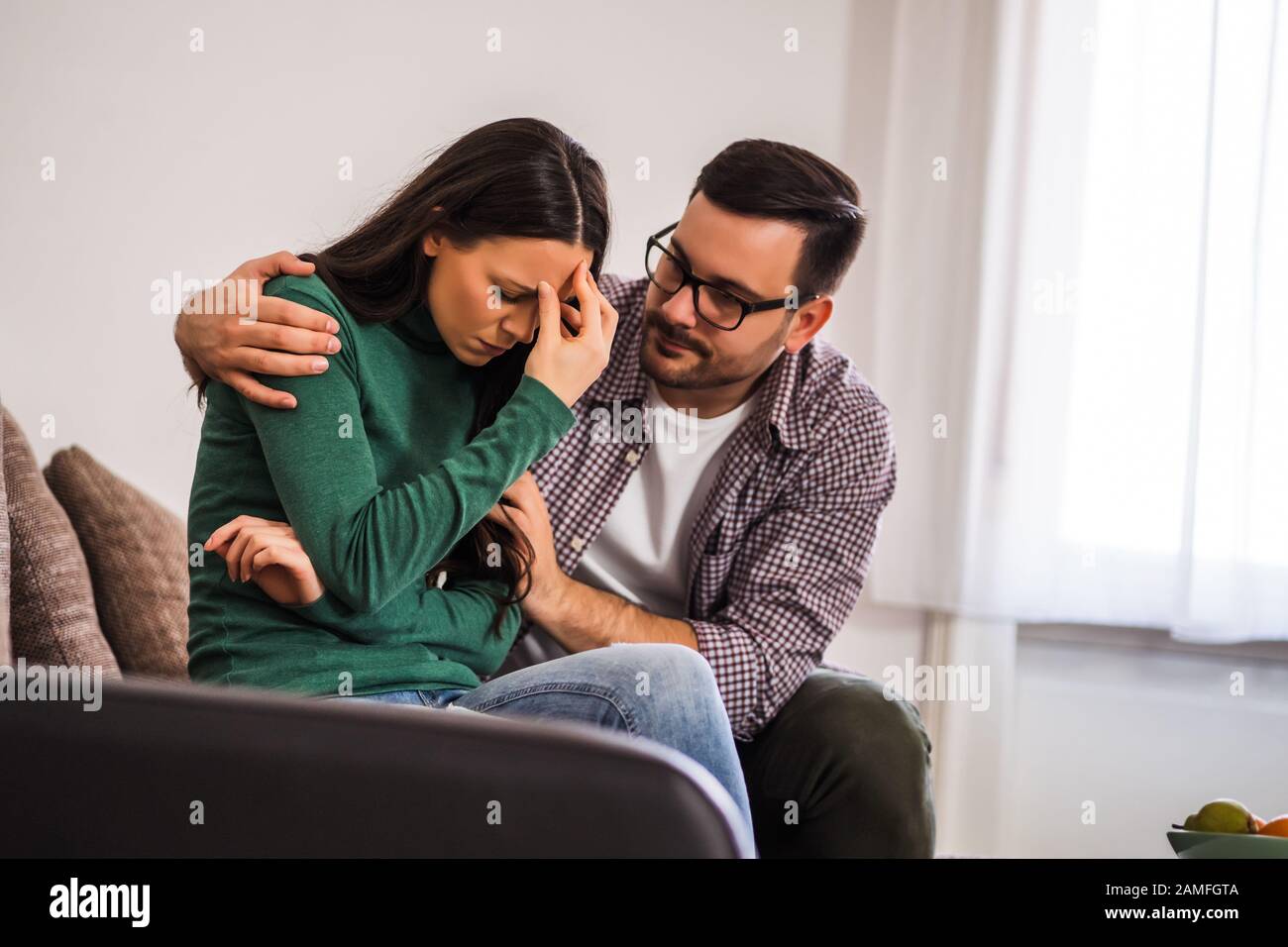 Woman is sad, her man is consoling her Stock Photo - Alamy