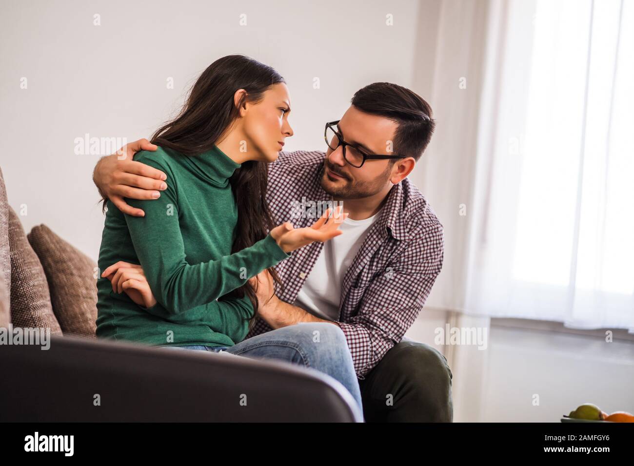 Woman is sad, her man is consoling her Stock Photo - Alamy