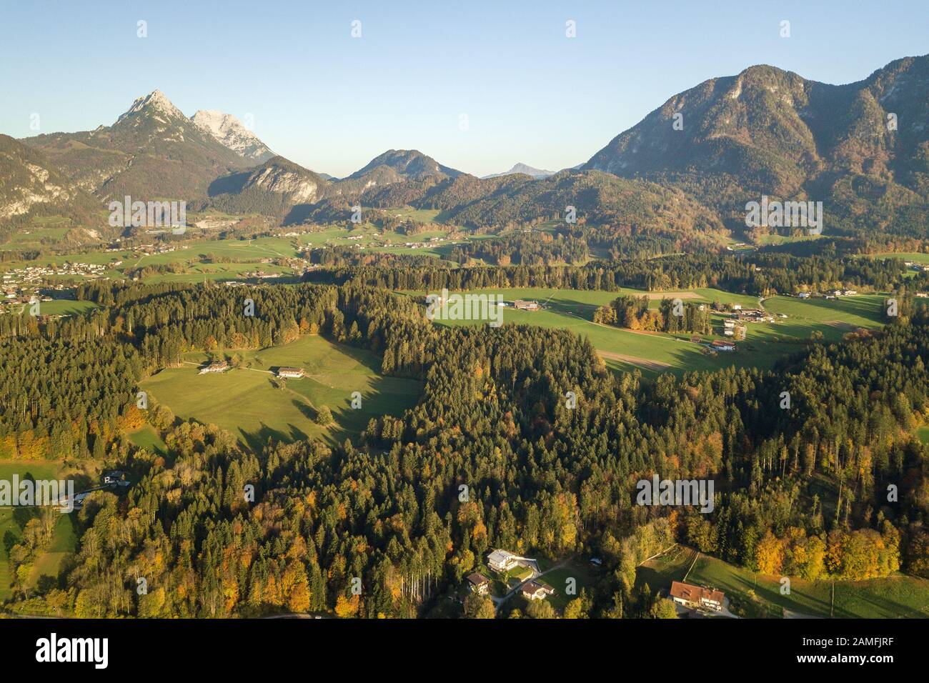 Aerial view of green meadows with villages and forest in austrian Alps ...