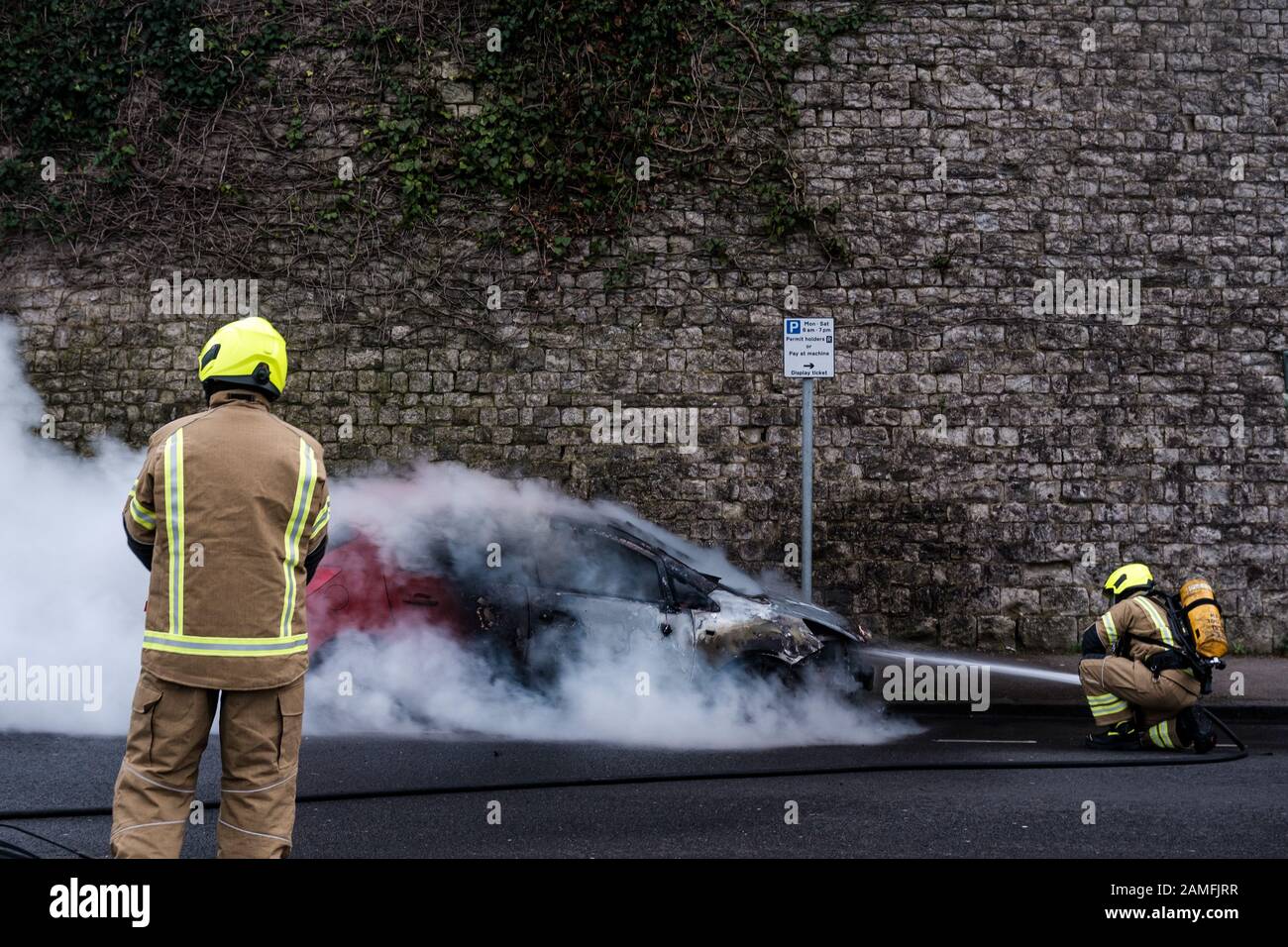 Members of the Kent Fire and Rescue service extinguishing a car fire on ...