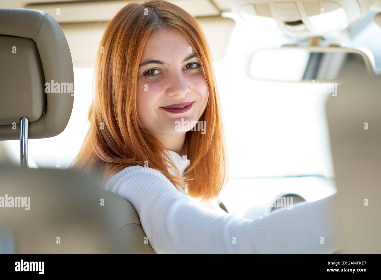 Young redhead woman driver driving a car smiling happily Stock Photo ...