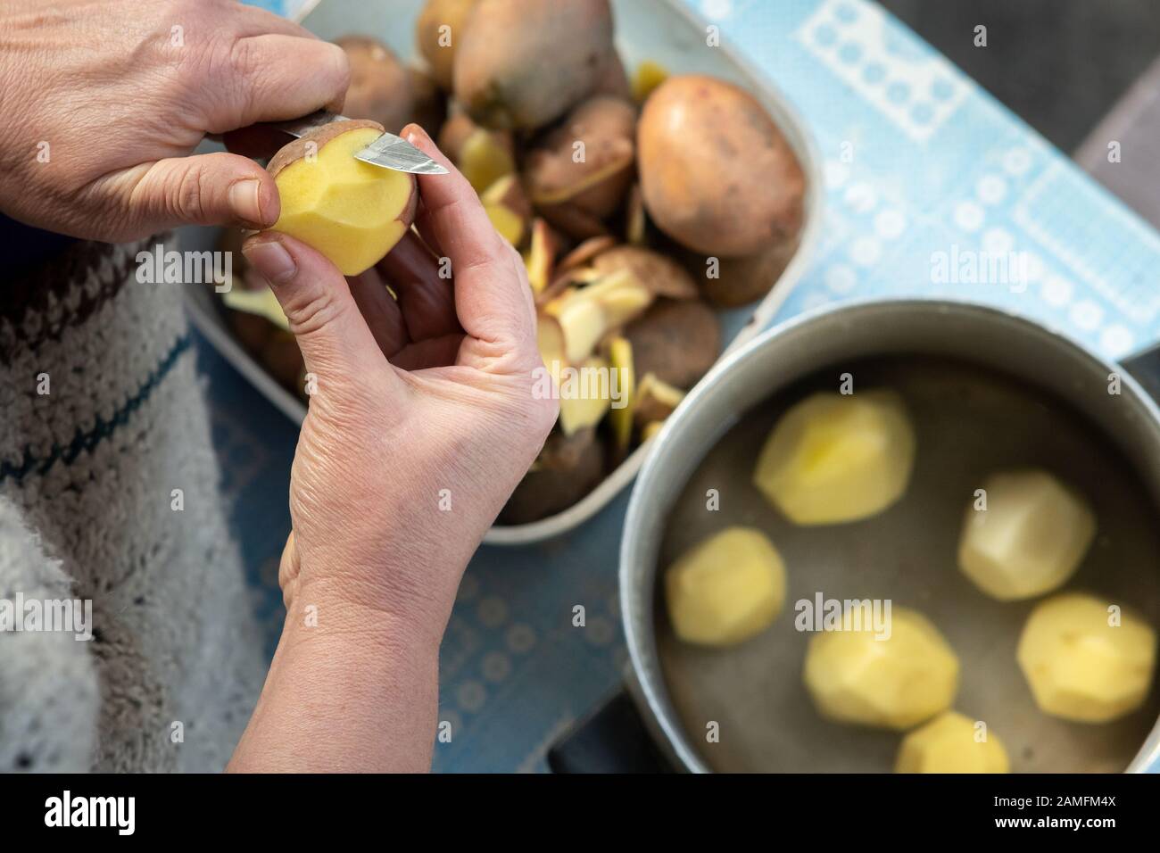 Closeup of woman hands peeling potatoes with a kitchen knife Stock ...