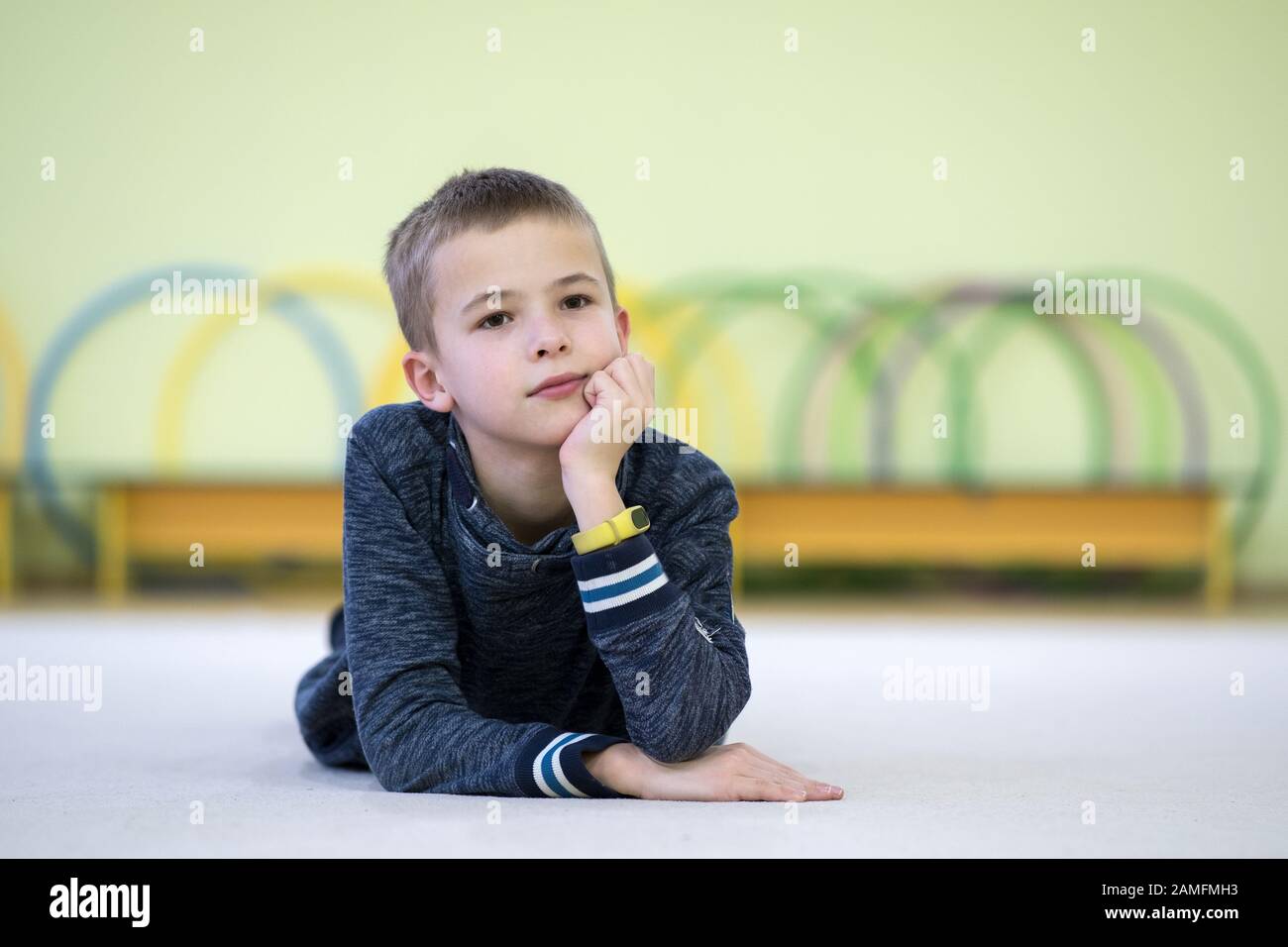 Young child boy laying down and relaxiong while resting on the floor ...