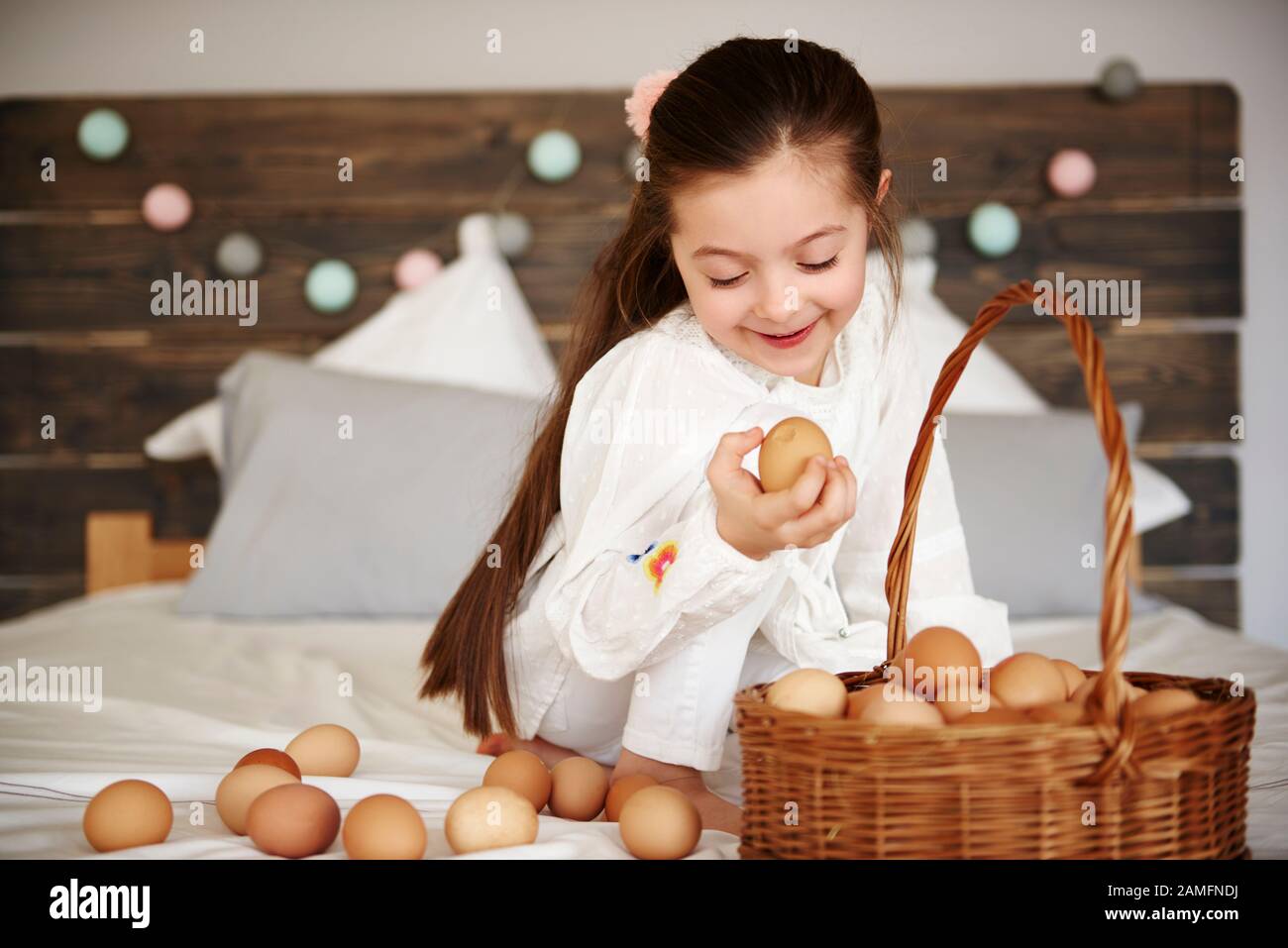 Cheerful girl watching the eggs in bed Stock Photo - Alamy