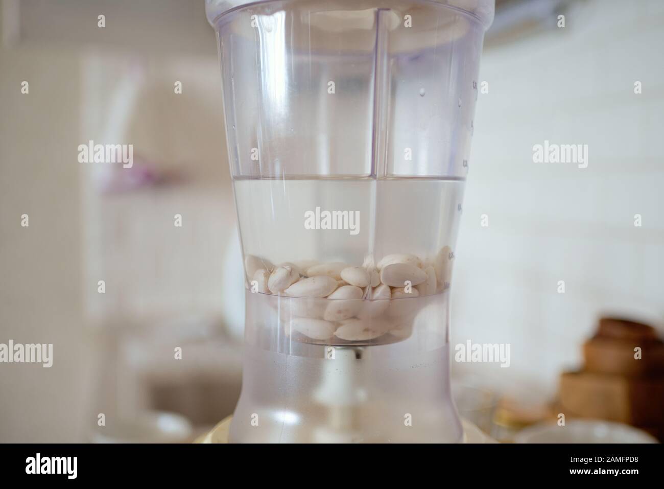 Blender and almonds soaked in water. Making healthy vegan milk Stock ...