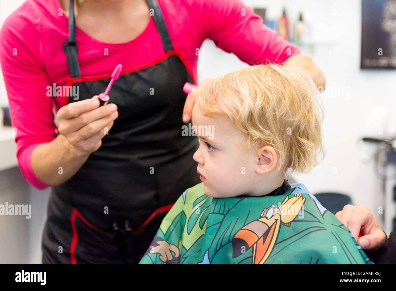 Cute blonde girl having her first haircut Stock Photo - Alamy