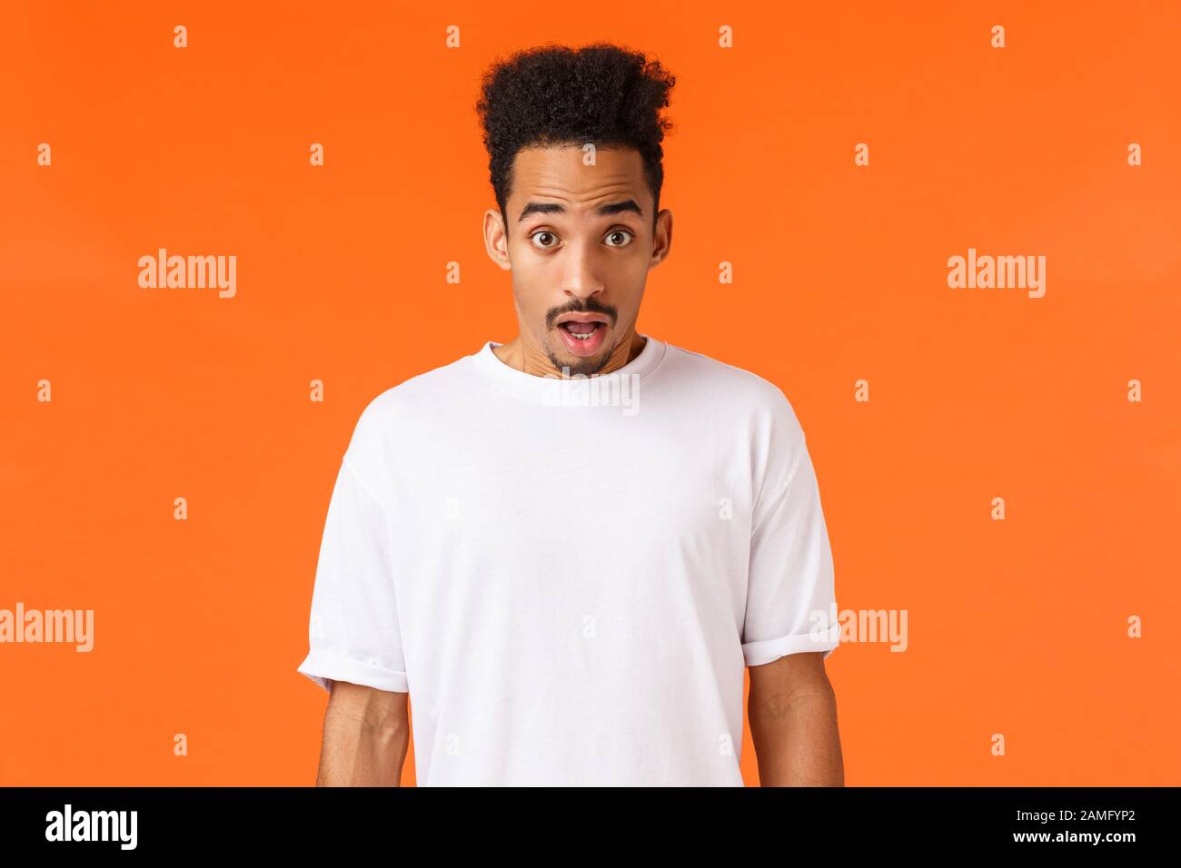 Startled, shocked african-american guy, drop jaw and stare camera with ...