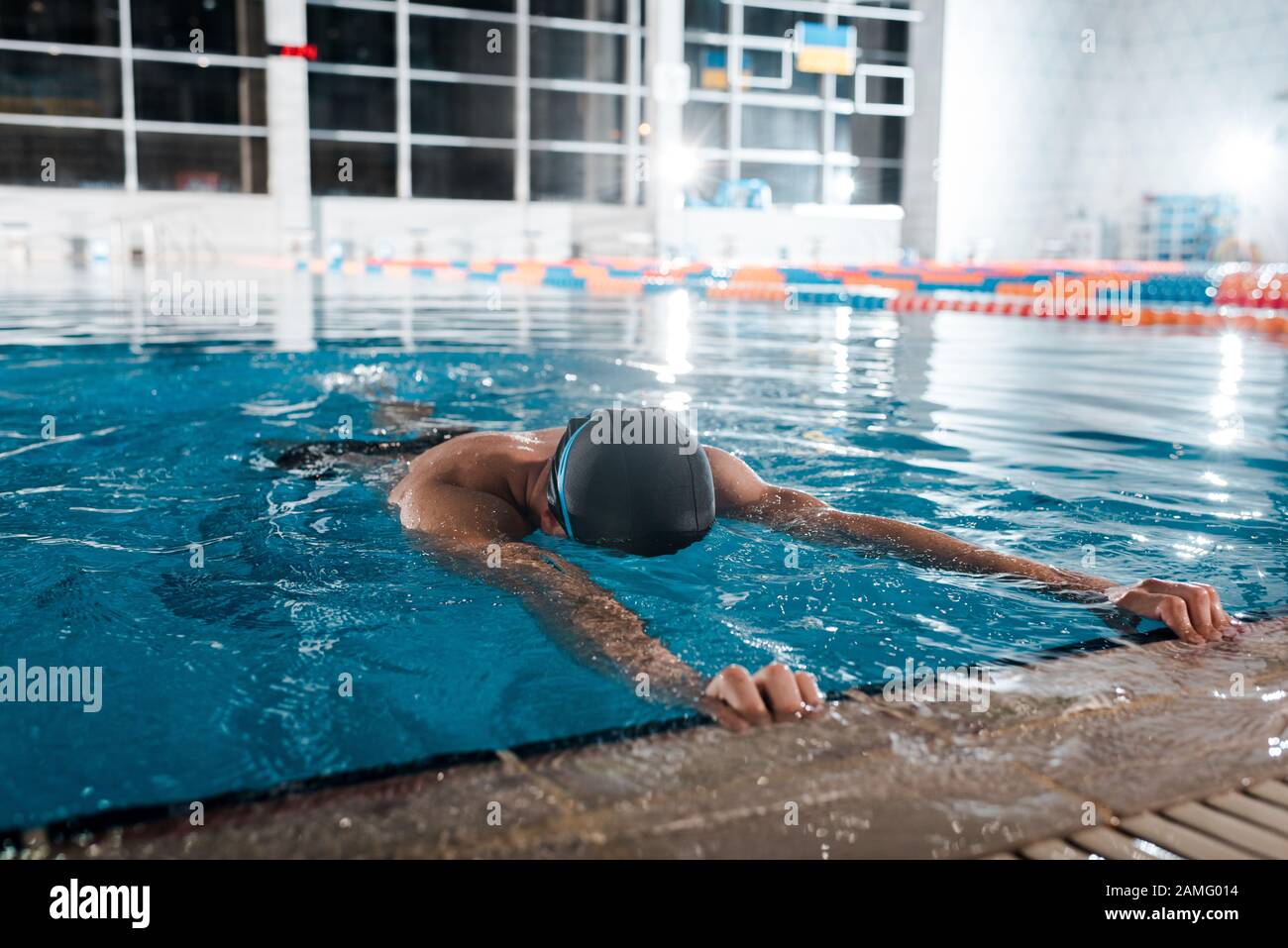man in swimming cap stretching in water Stock Photo - Alamy