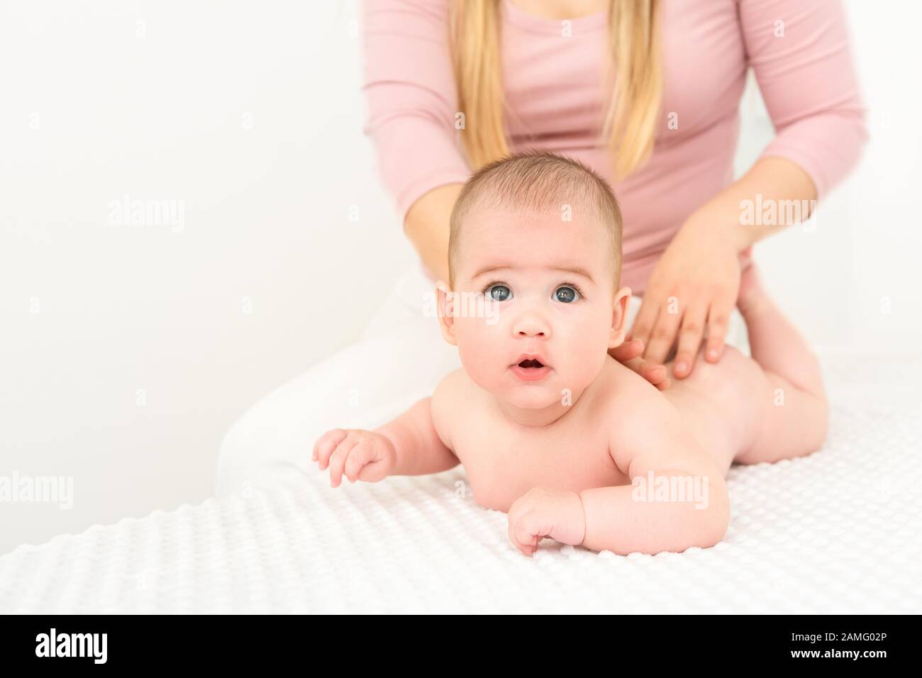 Baby massage background. Young therapist giving a baby boy a back ...
