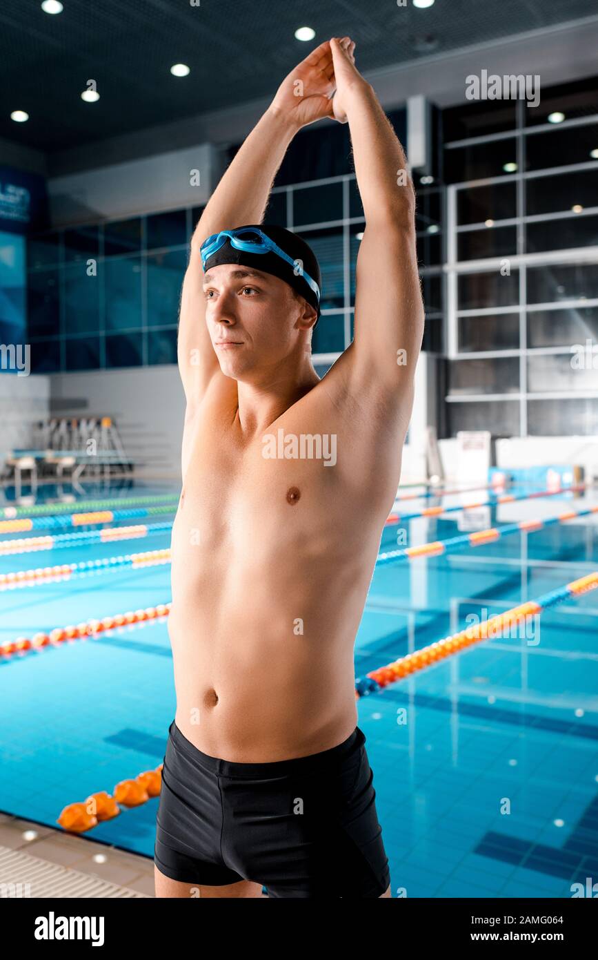 handsome shirtless swimmer stretching near swimming pool Stock Photo ...