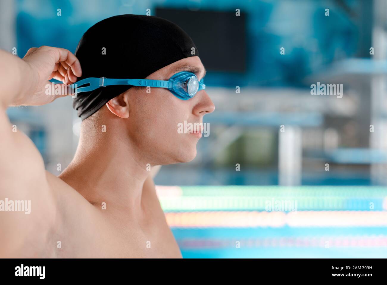 side view of handsome swimmer in swimming cap touching goggles Stock ...