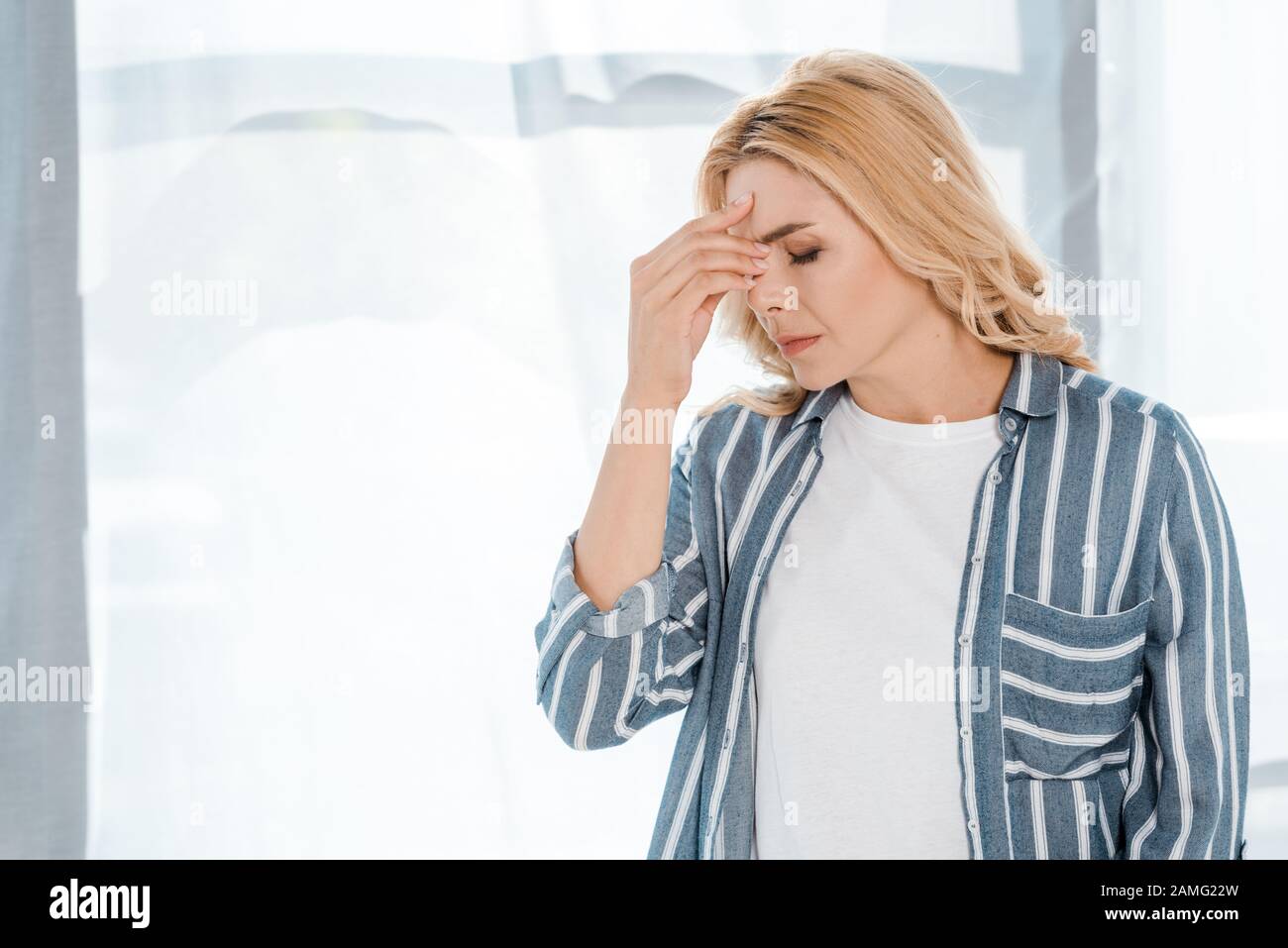 emotional woman touching head while having headache at home Stock Photo ...