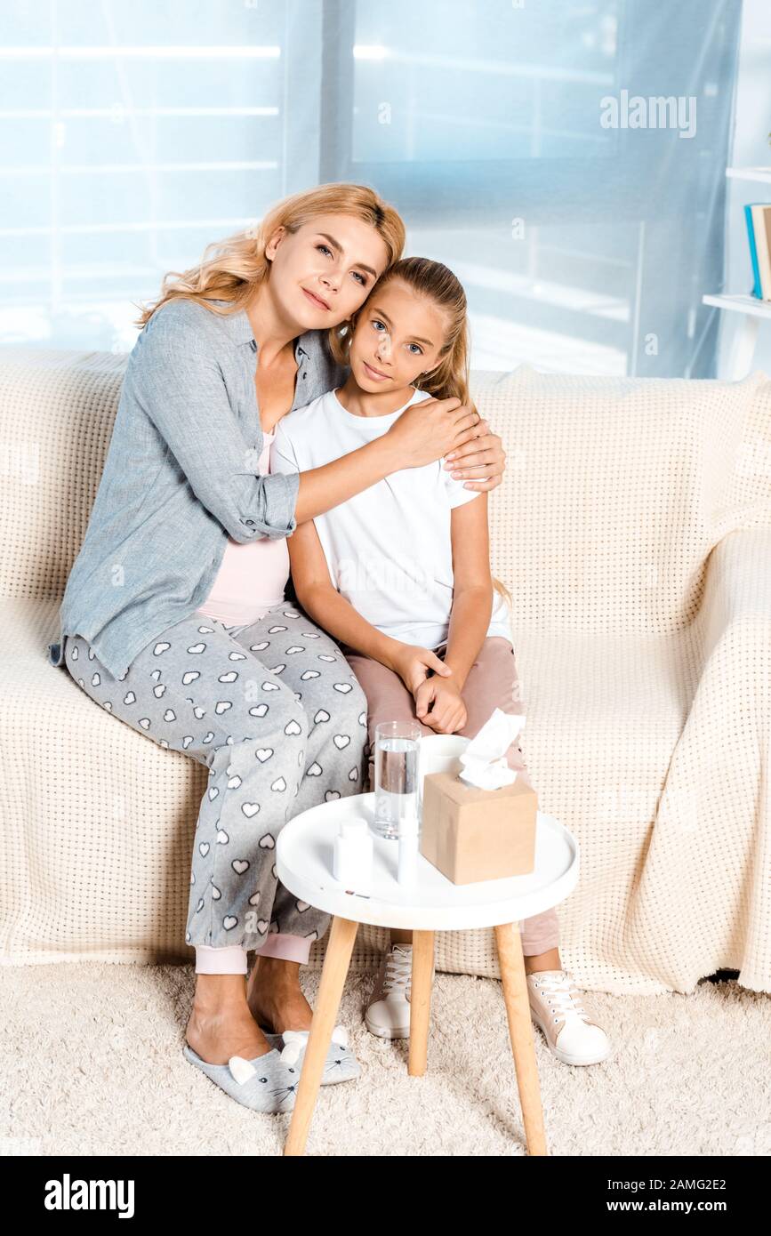 pregnant mother hugging daughter near table with tissue box Stock Photo ...