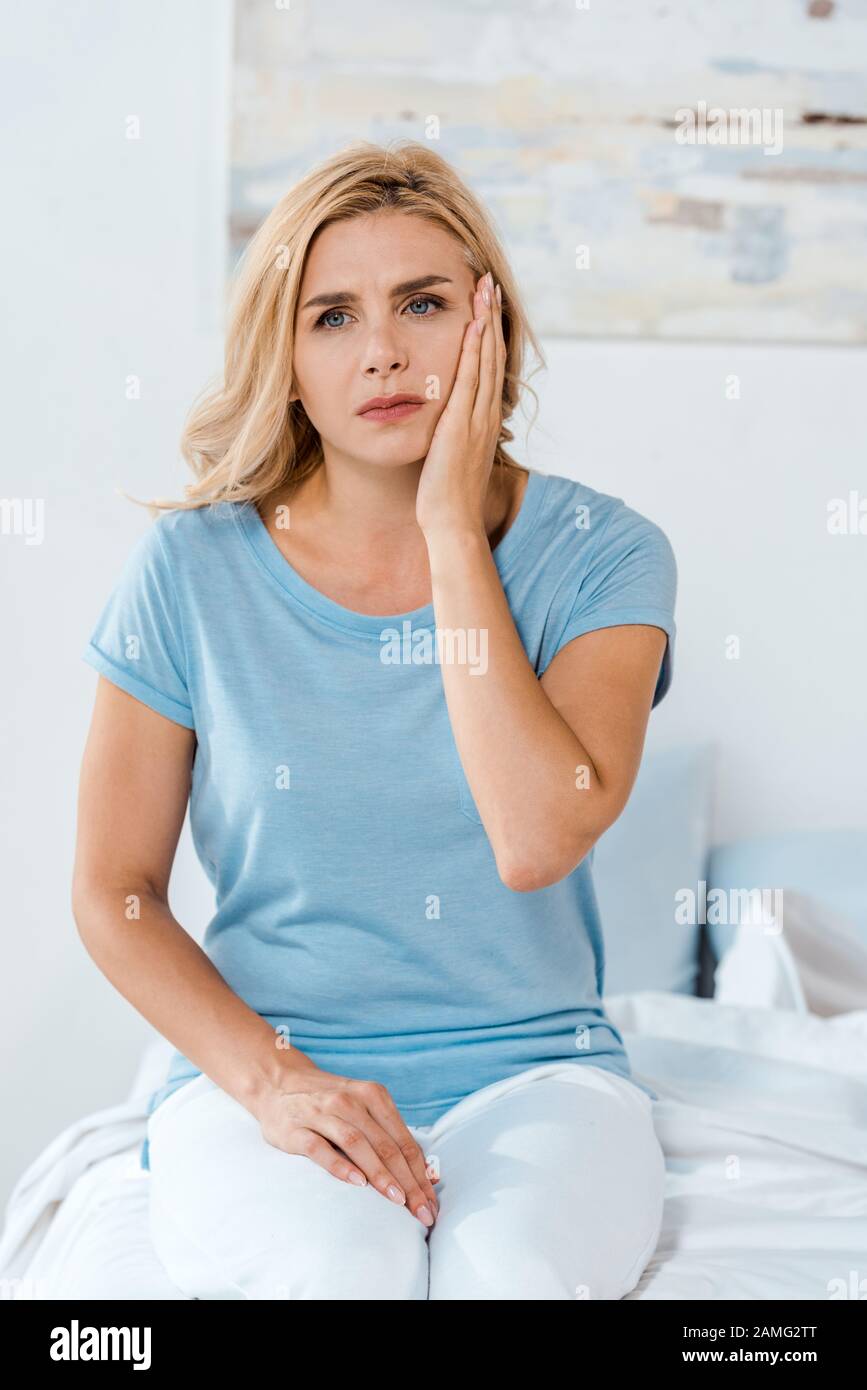 sad woman touching cheek while having tooth ache Stock Photo - Alamy