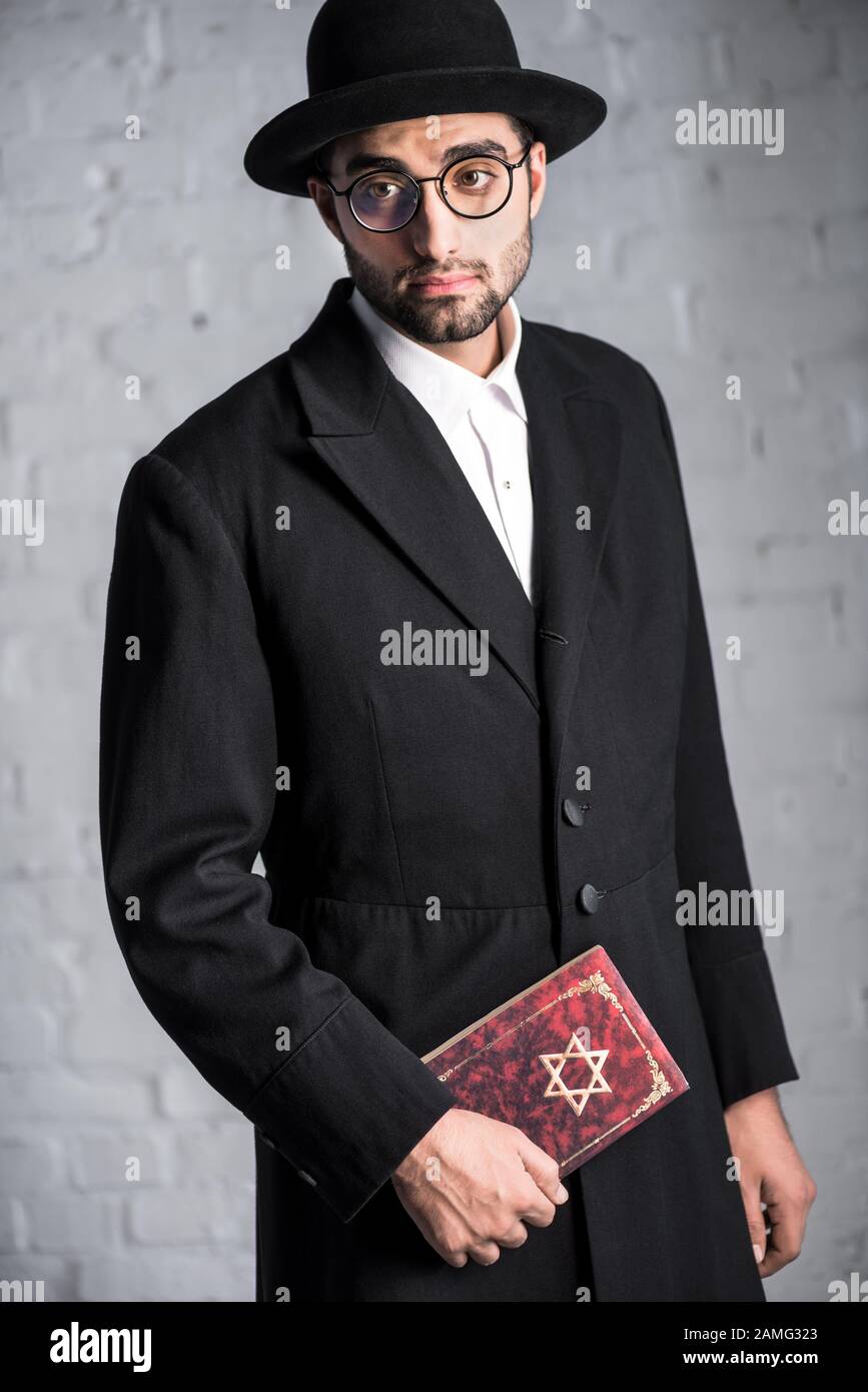 handsome and sad jewish man in glasses holding tanakh Stock Photo - Alamy