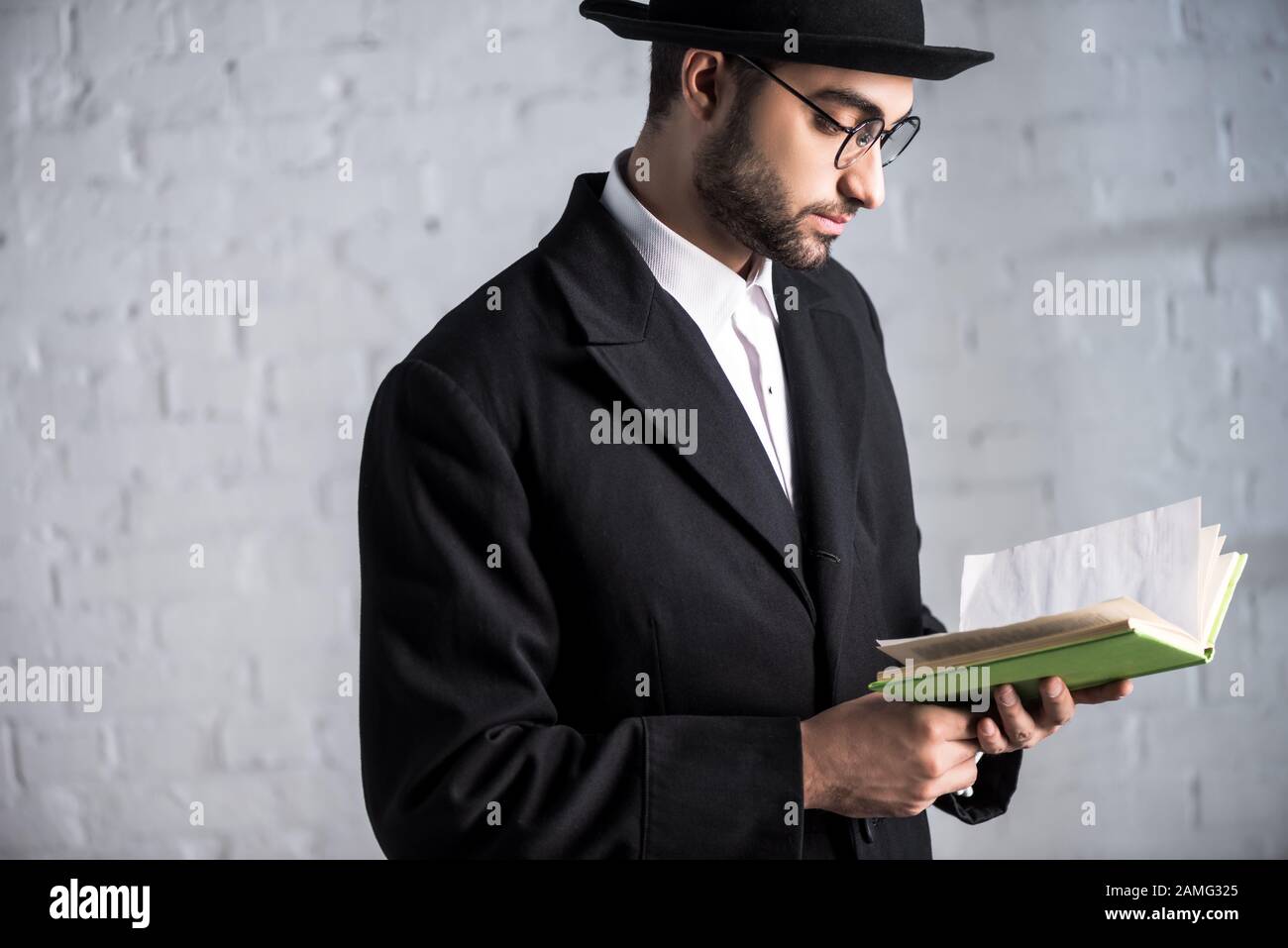 handsome and young jewish man in glasses reading book Stock Photo - Alamy